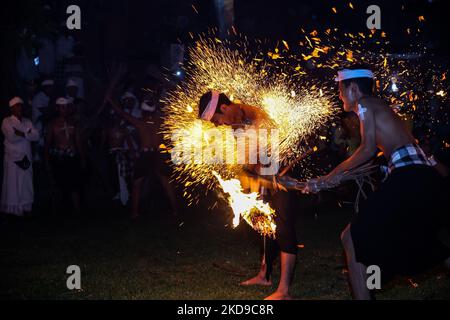 A Balinese man is hit with burning dried coconut leaves during a fire ...