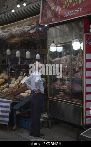 An Iranian elderly man looks at a shop window in a shopping center in ...