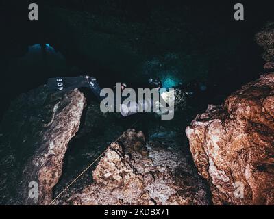 A scuba diver exploring the mysterious rocky cave Stock Photo - Alamy