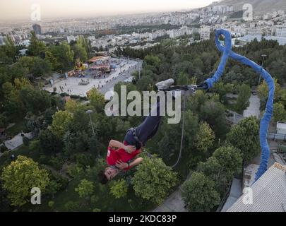 An Iranian bungee man makes a bungee jump from a 40-meter rig during ...