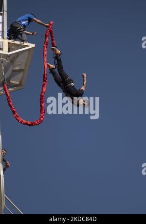 An Iranian bungee man makes a bungee jump from a 40-meter rig during ...