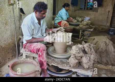 Potter skillfully shapes an earthen pot on a large potter's wheel at a ...