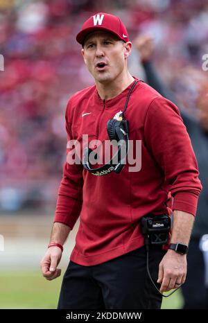 Washington State coach Jake Dickert leads his team onto the field to ...
