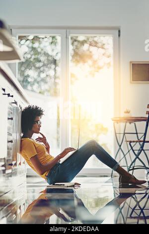 Spending a little time online. Shot of a handsome young man using his ...