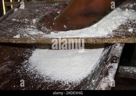 Woman demonstrates preparing and cooking yucca root tortillas in an ...