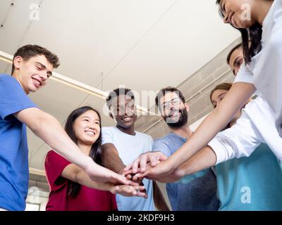Group of multiethnic teenage students shaking hands with teacher as a ...