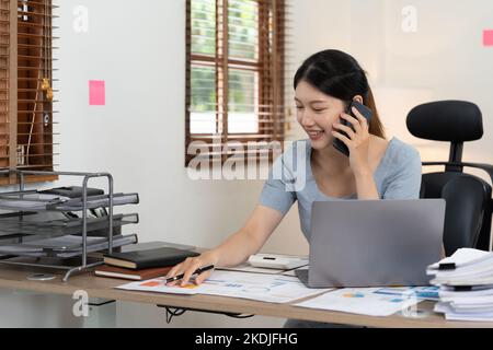 Young accountant with smartphone to call marketing consultants and ...