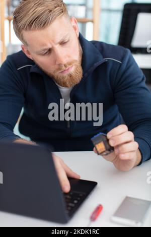 Young male contractor repairing computer Stock Photo - Alamy