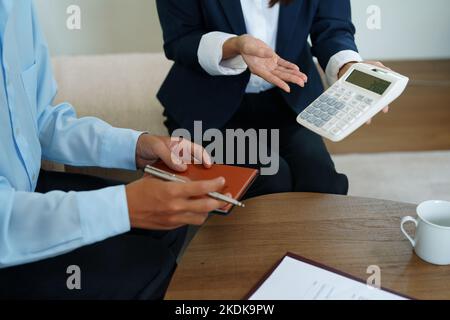 bank employee uses a calculator to calculate loan rates for customers ...