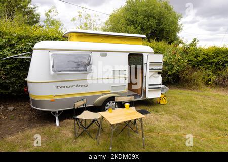 Caravan UK - a yellow touring Eriba Caravan, side view, with table and ...