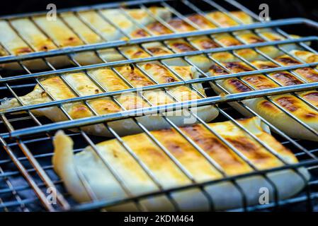Squid carcasses are cooked on a grill Stock Photo - Alamy