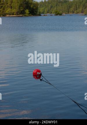 A red bouy used for mooring small boats in a lake Stock Photo - Alamy