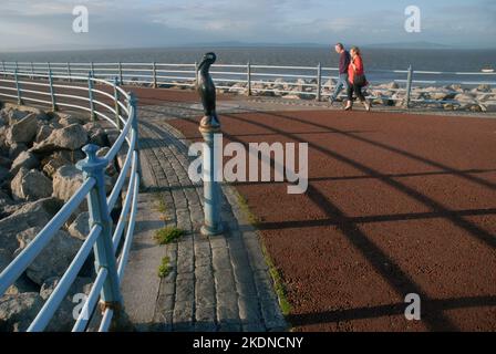Sculpture of Cormorant on rail, Morecambe bay and the promenade ...