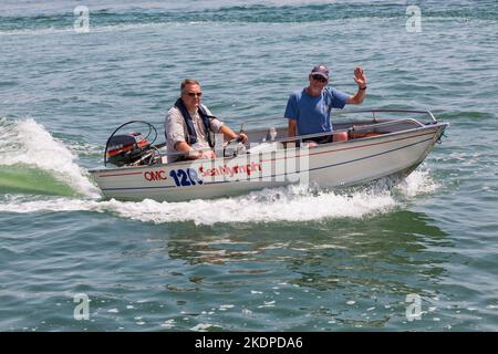 Two men in OMC 12R Sea Nymph boat motoring to the entrance to ...