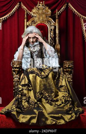 senior queen in a dress sits on a throne Stock Photo - Alamy
