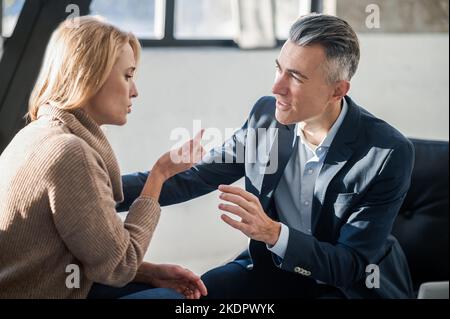 Psychologist talking to a client and looking friendly Stock Photo - Alamy