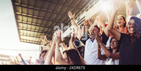 A crowd of people with raised arms during a music concert with an ...