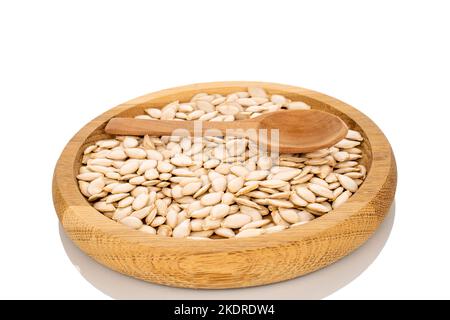 Unpeeled raw pumpkin seeds with wooden spoon, macro, isolated on white ...