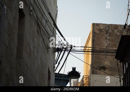 Malta electric wires hanging on building detail Stock Photo - Alamy