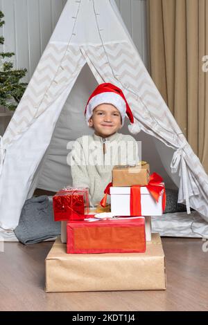 Teen boy in sweater looking away against waving sea and sundown sky in ...