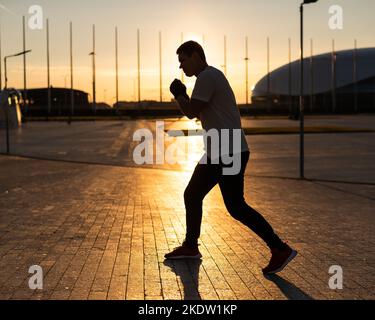 A man trains boxing at sunset outdoors Stock Photo - Alamy