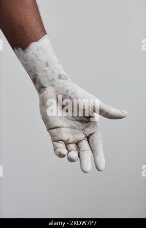 Minimal closeup of male hand covered in white paint or plaster, human ...
