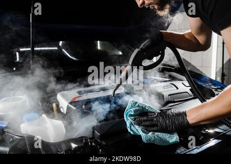 Detailing cleaning motor from dust and dirt. Pouring water on car ...