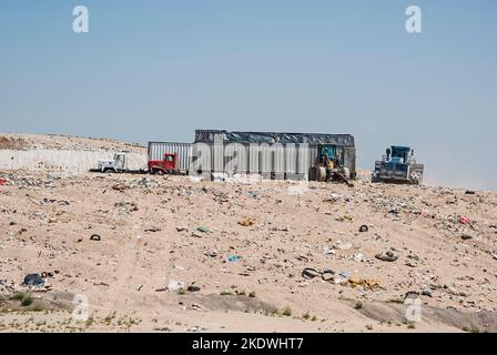 A tractor-trailer semi and two soil compactors on flat land in an ...