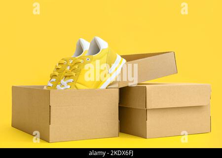 Cardboard boxes with sneakers on yellow background Stock Photo - Alamy