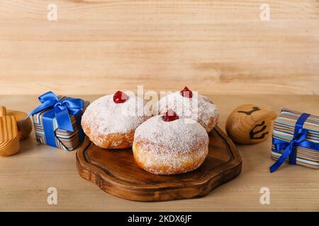 Board with tasty donuts, gifts and dreidels for Hannukah celebration on ...