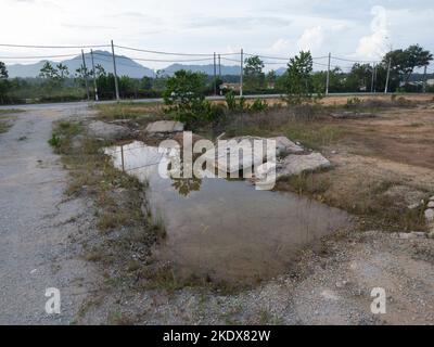 reflective puddle with stagnant water on the roadside after the rain ...