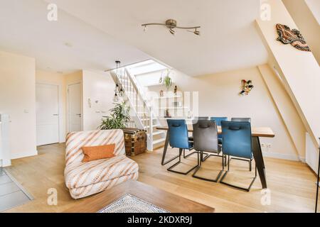 Table with chairs and flowers located near lounge area and kitchen in ...