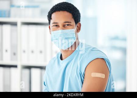 a man in a medical mask with a plaster on his shoulder yellow t-shirt ...