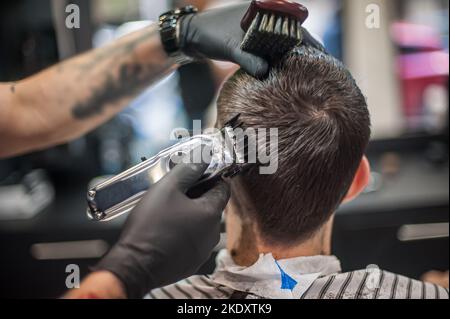 Modern urban hairdresser cut hair with hair trimmer in professional ...