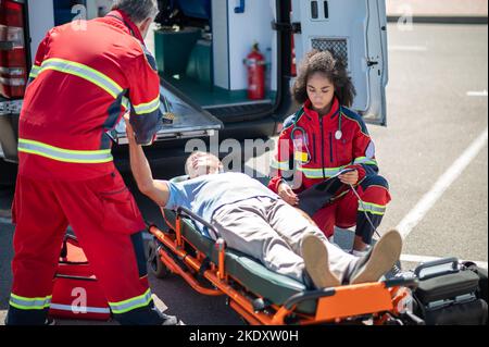 Paramedical staff providing emergency care to a car accident victim ...