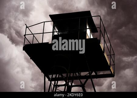 Dark silhouette of the metal structure of the watchtower, clouds in the ...
