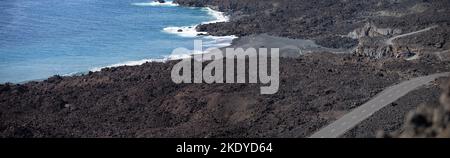 A shot of waves washing the gray sand beach surrounded by soil Stock ...