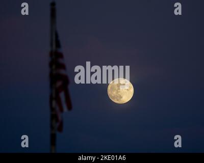 A full moon glows with a yellow tint as it rises above Phoenix Arizona ...