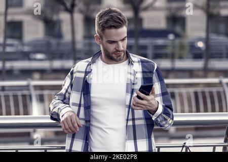 Your true companion. Handsome man use phone outdoors. Online chatting ...