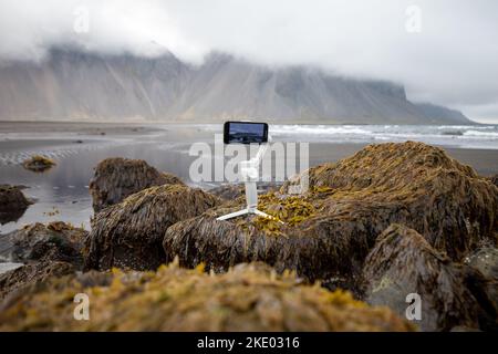 The Smartphone Gimbal on Stockness Beach in Iceland with mountains in ...