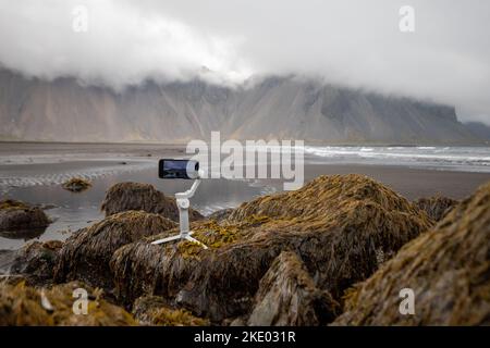 The Smartphone Gimbal on Stockness Beach in Iceland with mountains in ...