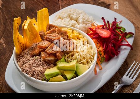 A top view of a plate with a traditional Bandeja paisa dish with ...