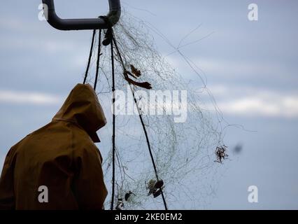 Inshore fishing sailors fish in their traditional wooden boat in the ...