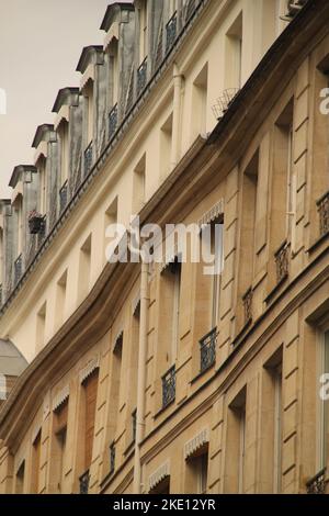 The facade of a beige building with long narrow windows in downtown ...