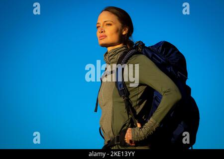 A woman with a backpack on looking into the distance Stock Photo - Alamy