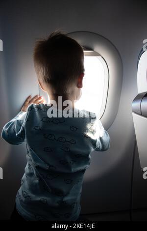 Little boy looking out of airplane window Stock Photo - Alamy