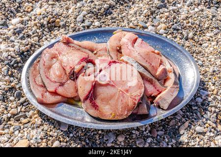 Overhead view of grilled slices of swordfish in a barbecue grill with a ...