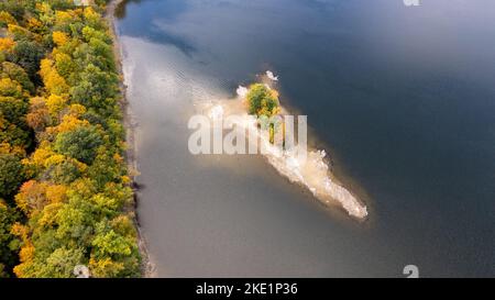 A drone shot of the New Croton Reservoir on a sunny day in autumn with ...