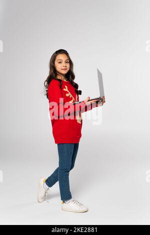 smiling child in knitwear hold toy. teen girl on blue background. happy ...