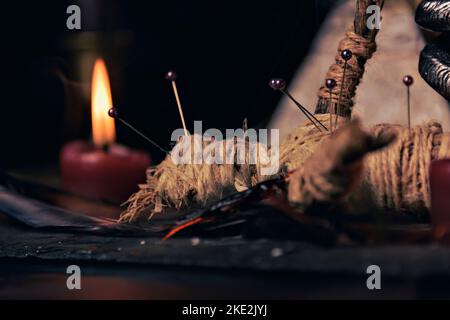 Voodoo doll in ritual scene close up, magic table with candles ...